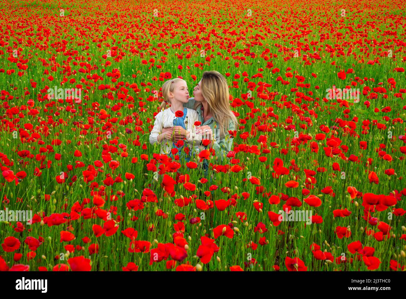 Happy family resting on a beautiful poppy field. Family having fun ...