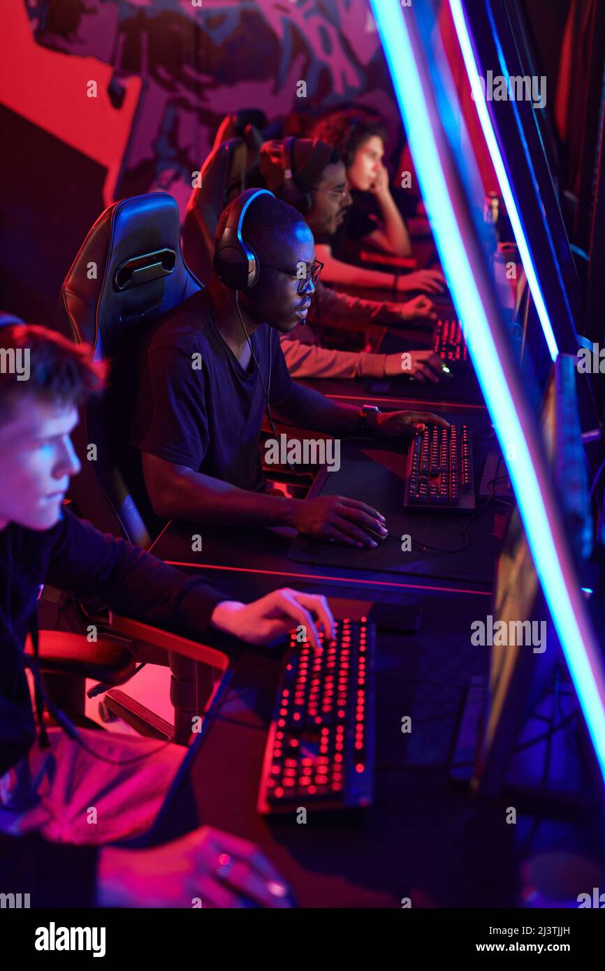 Group of serious young multi-ethnic men playing video games while ...