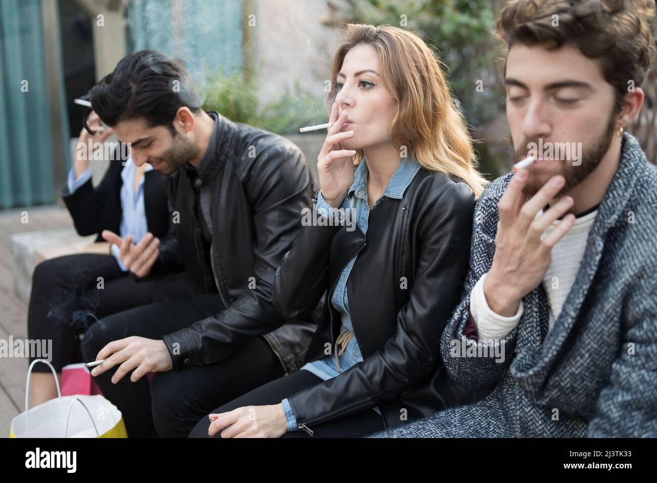 Bad habits - group of young friends smoking cigarettes together ...