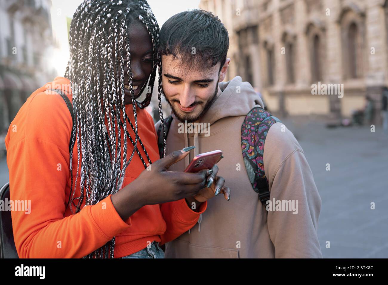 Multi-ethnic engaged couple of tourists watching content on the ...