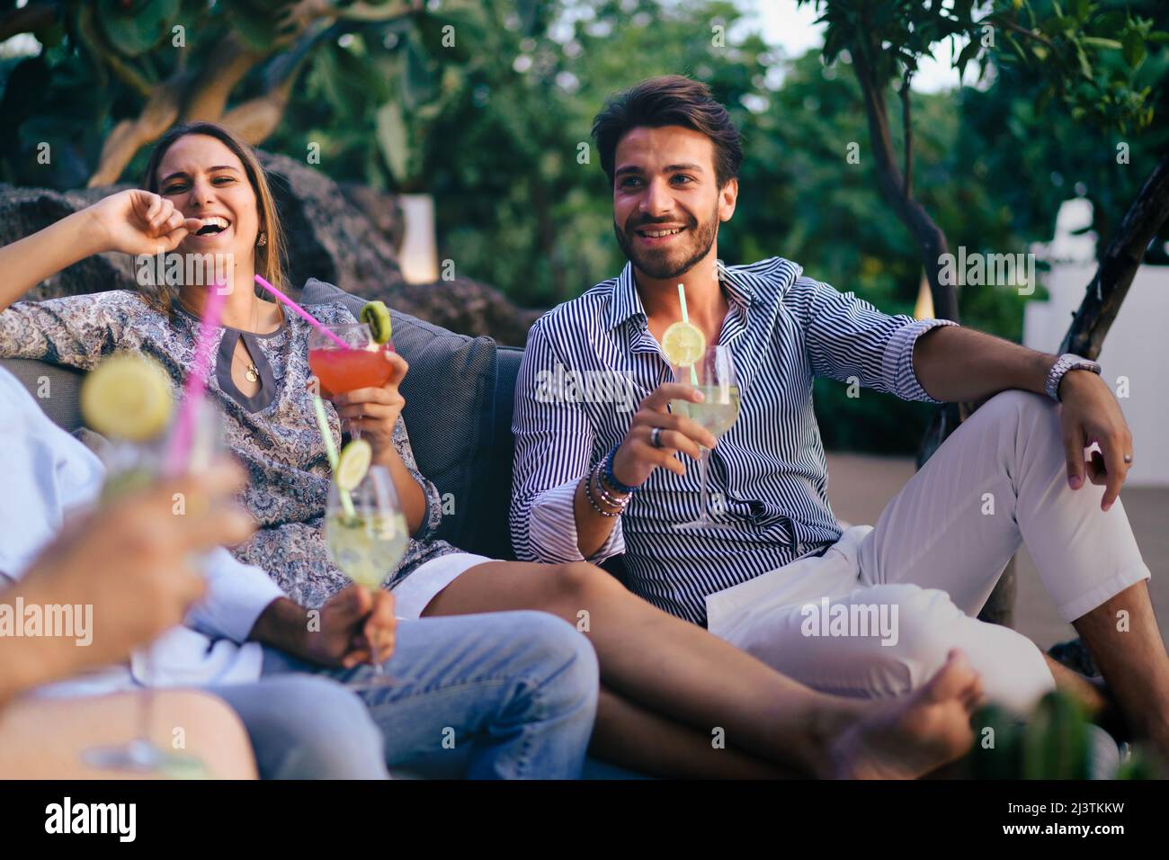 Group of young people carefree sitting at the terrace garden talking ...