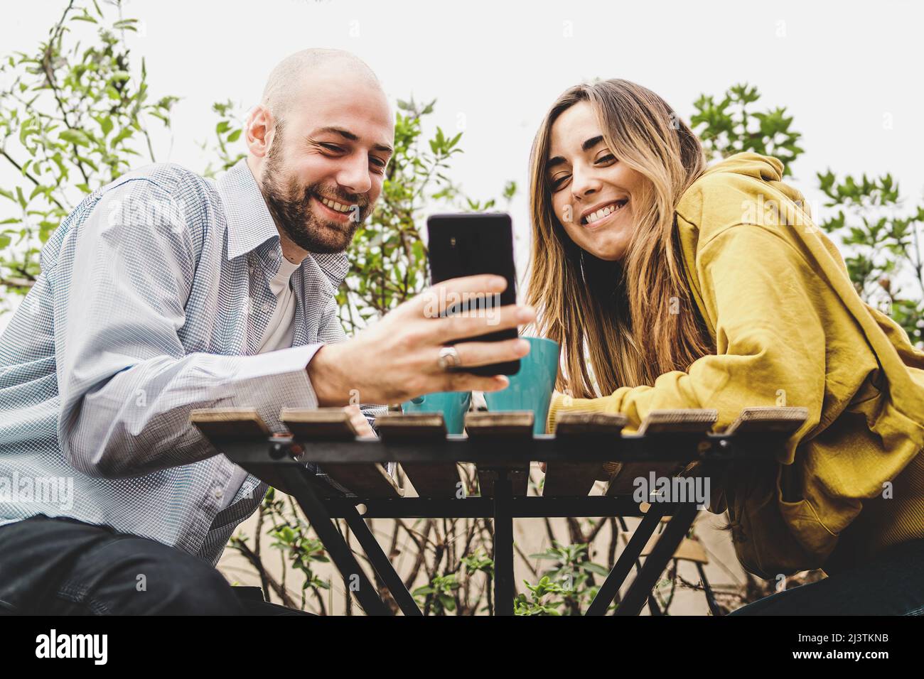 Two young people using smartphone mobile phone watching social media ...