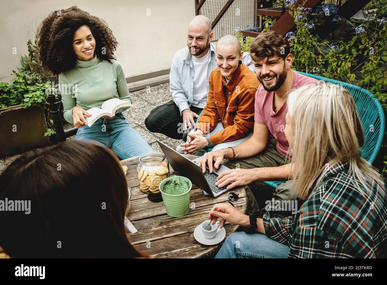 Multicultural university students using laptop around a table in the ...