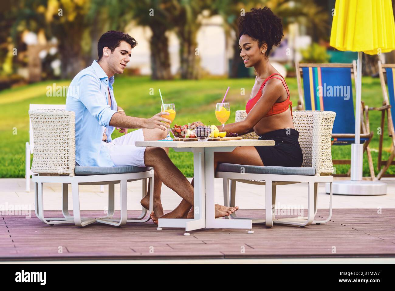 multiracial couple eating healthy fruit breakfast at luxury resort ...