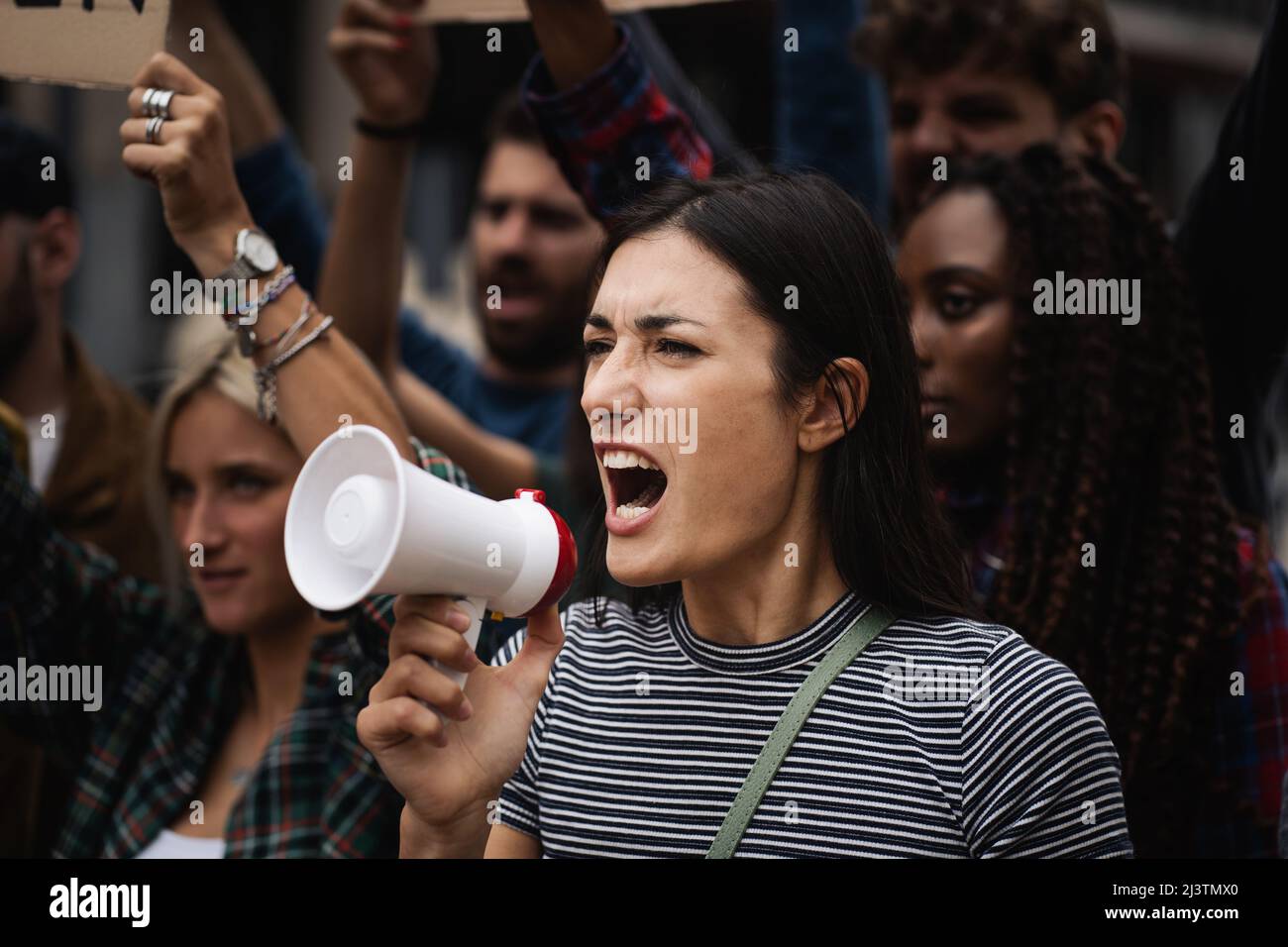 Young caucasian woman protester demonstrate shouting loud through ...