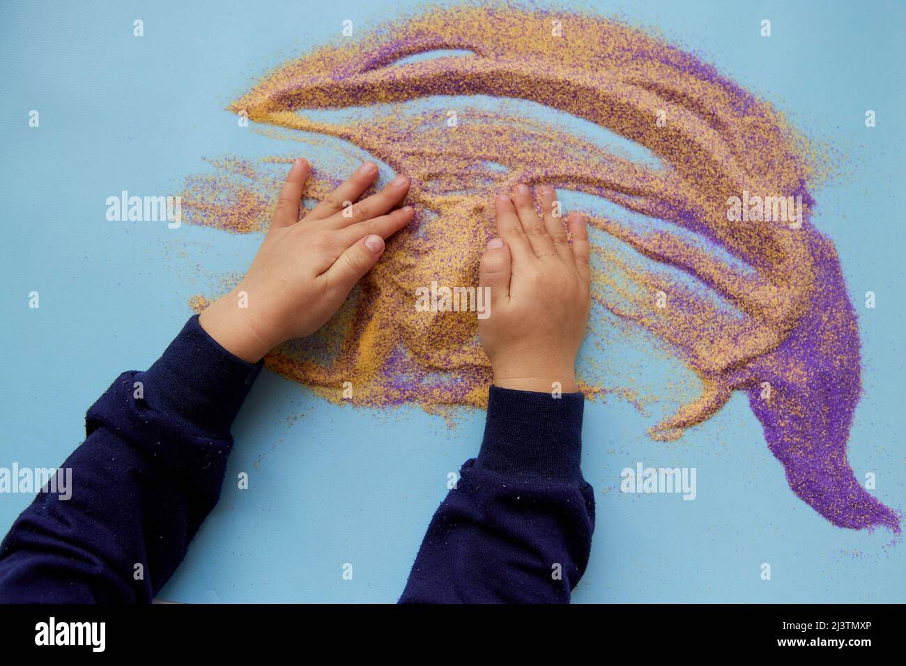Baby plays with colorful sand. Child fine motor skills development ...