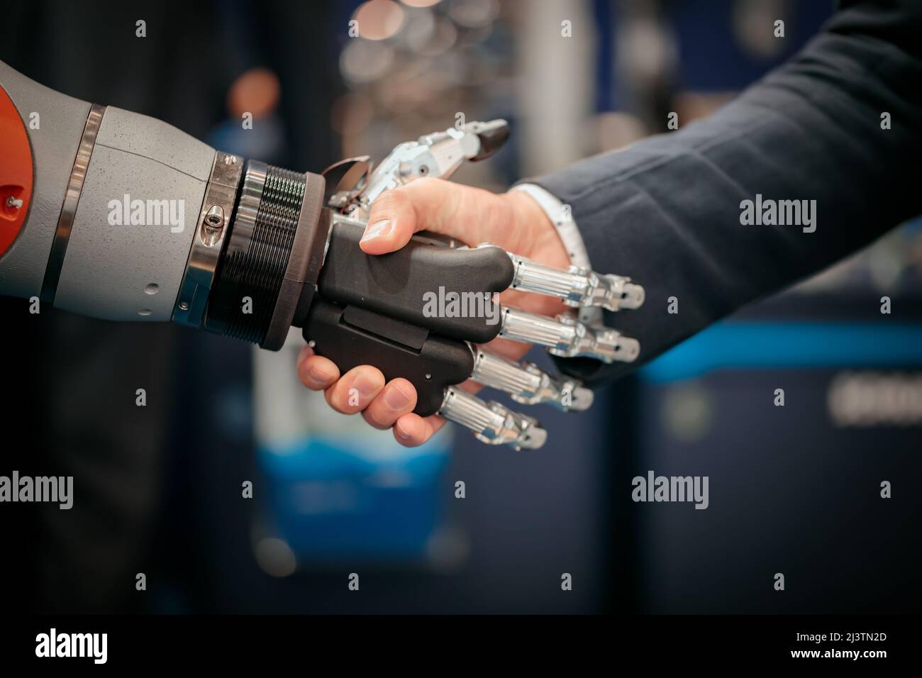 Hand of a businessman shaking hands with a Android robot. The concept ...