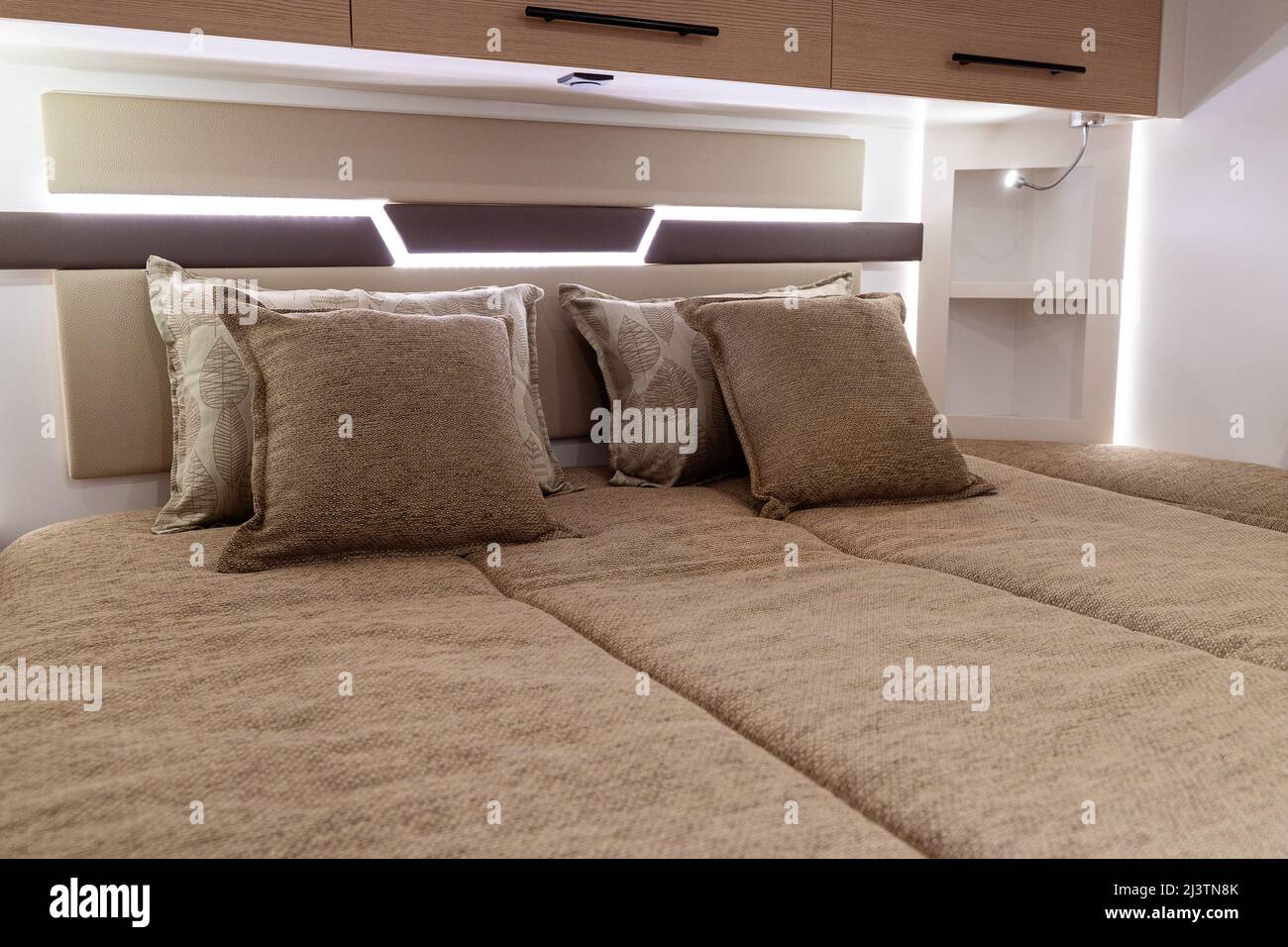 closeup of bed and pillows inside empty bedroom in luxury RV camper ...