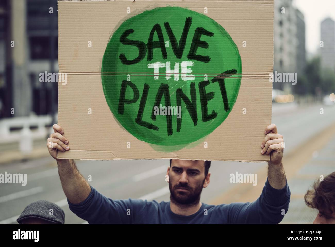 Portrait of an activist marching for rights and showing the sign "Save ...