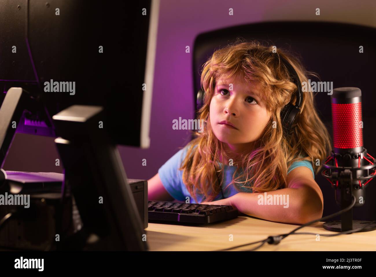 Kid with computer late at night. Neon blue light Stock Photo - Alamy