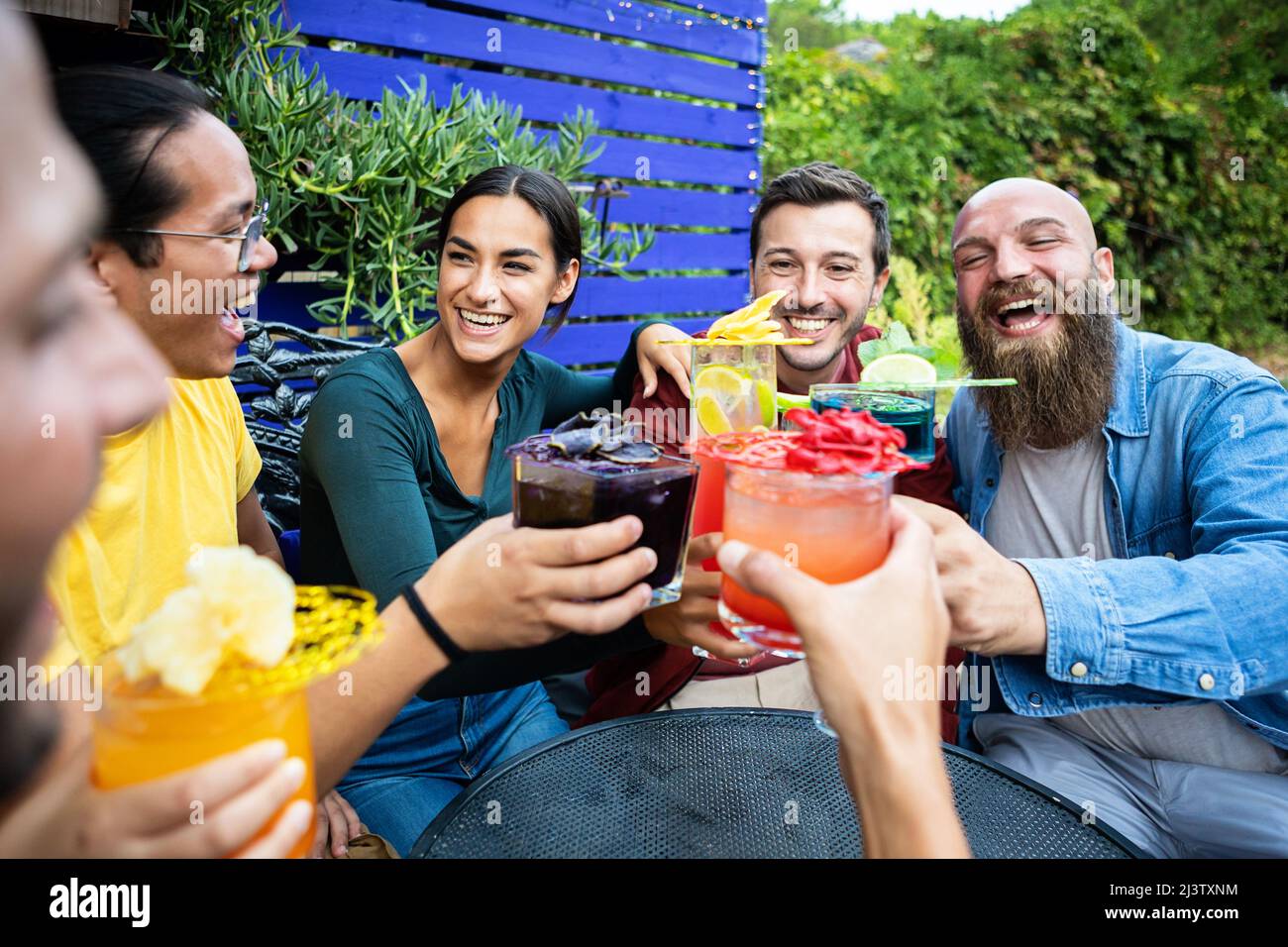Happy trendy friends celebrating together while cheering with cocktails ...