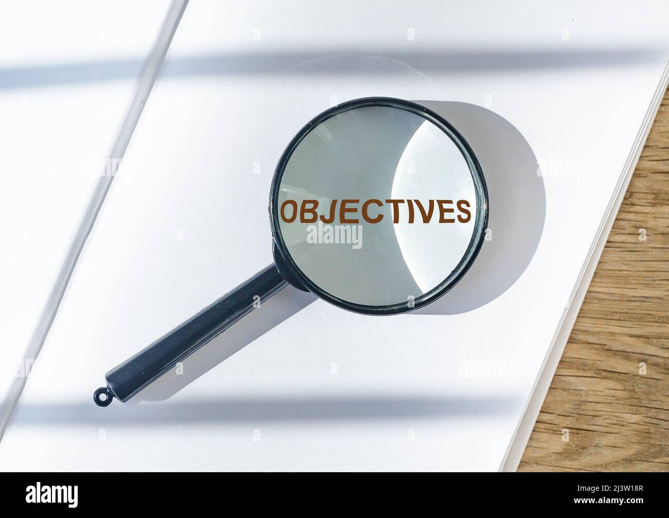 Objective, aim word through magnifying lens on book page. High quality ...