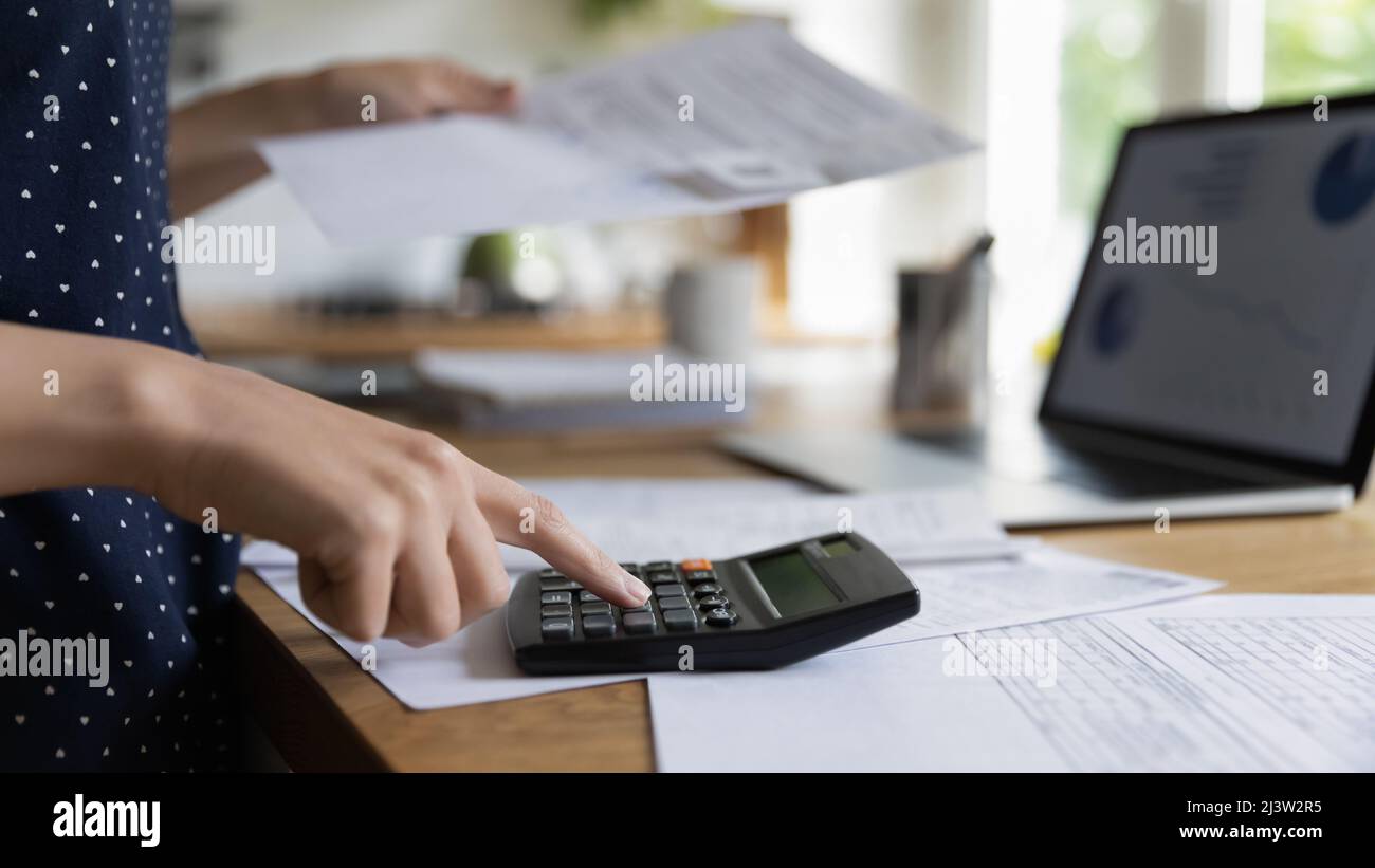 Female accountant hand makes calculations, closeup bills and calculator ...