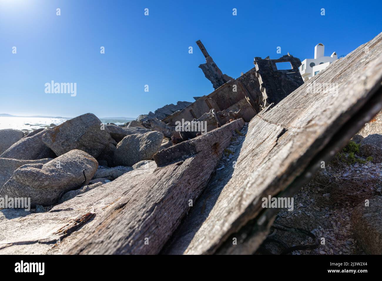 Wooden disintegrating hull of of shipwrecked boat next to rocks Stock ...