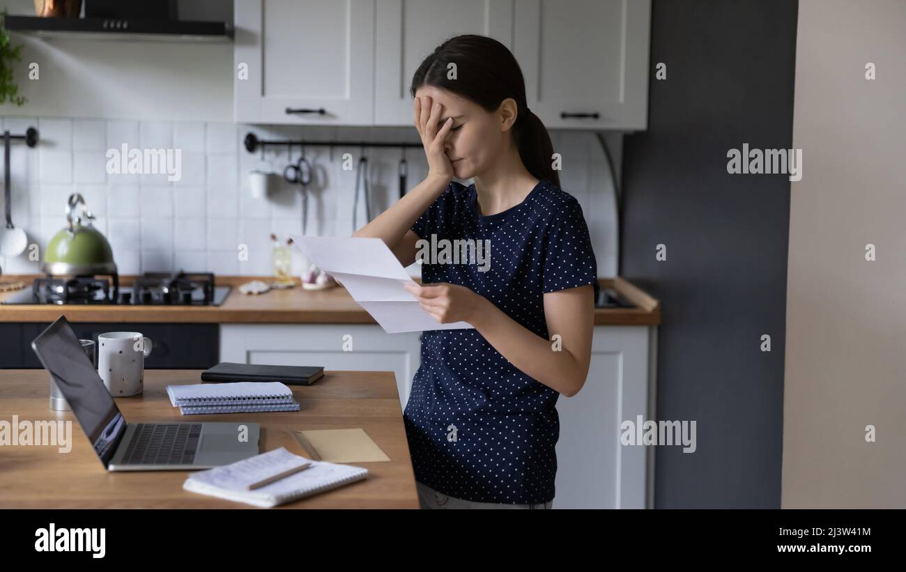 Woman reading letter with awful news feels frustrated Stock Photo - Alamy