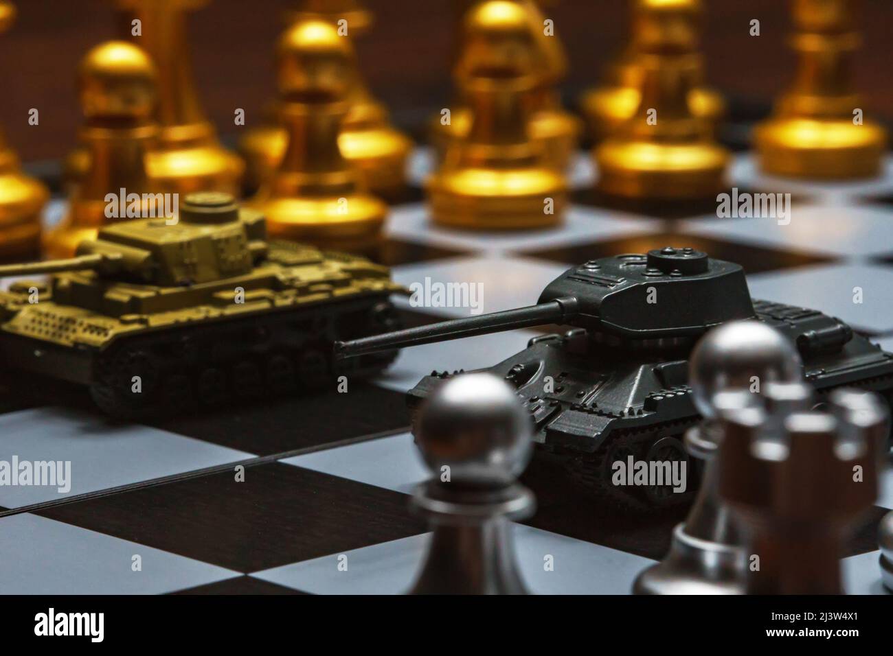 Toy tanks with chess on chessboard. Concept of military strategy Stock ...
