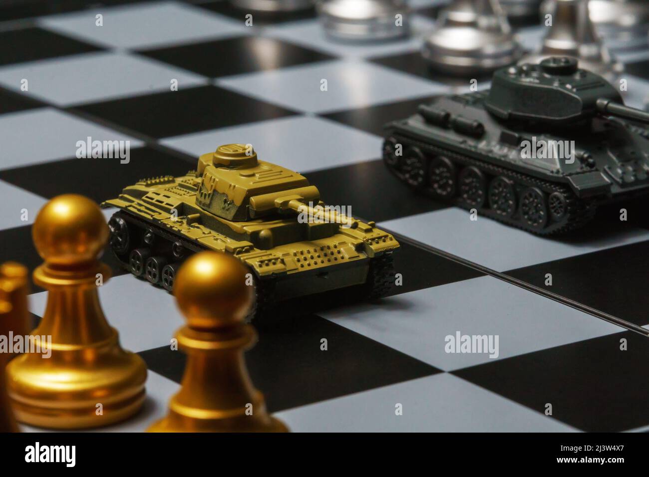 Toy tanks with chess on chessboard. Concept of military strategy Stock ...