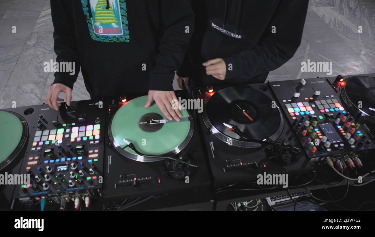 Two DJs are mixing music on console. Art. People are setting up music ...