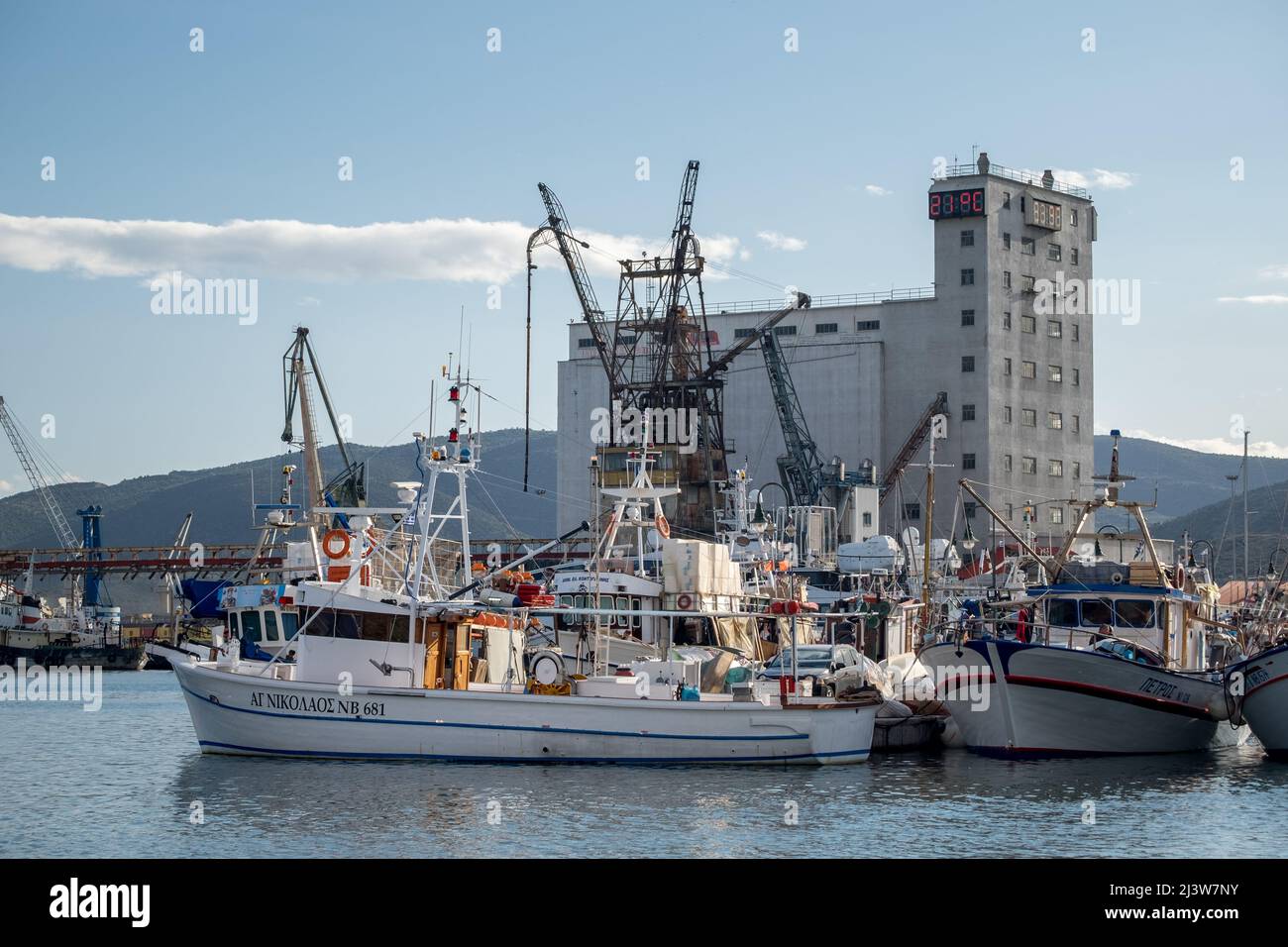 Seascape scenery with fishing boats and big port cranes on the harbor ...