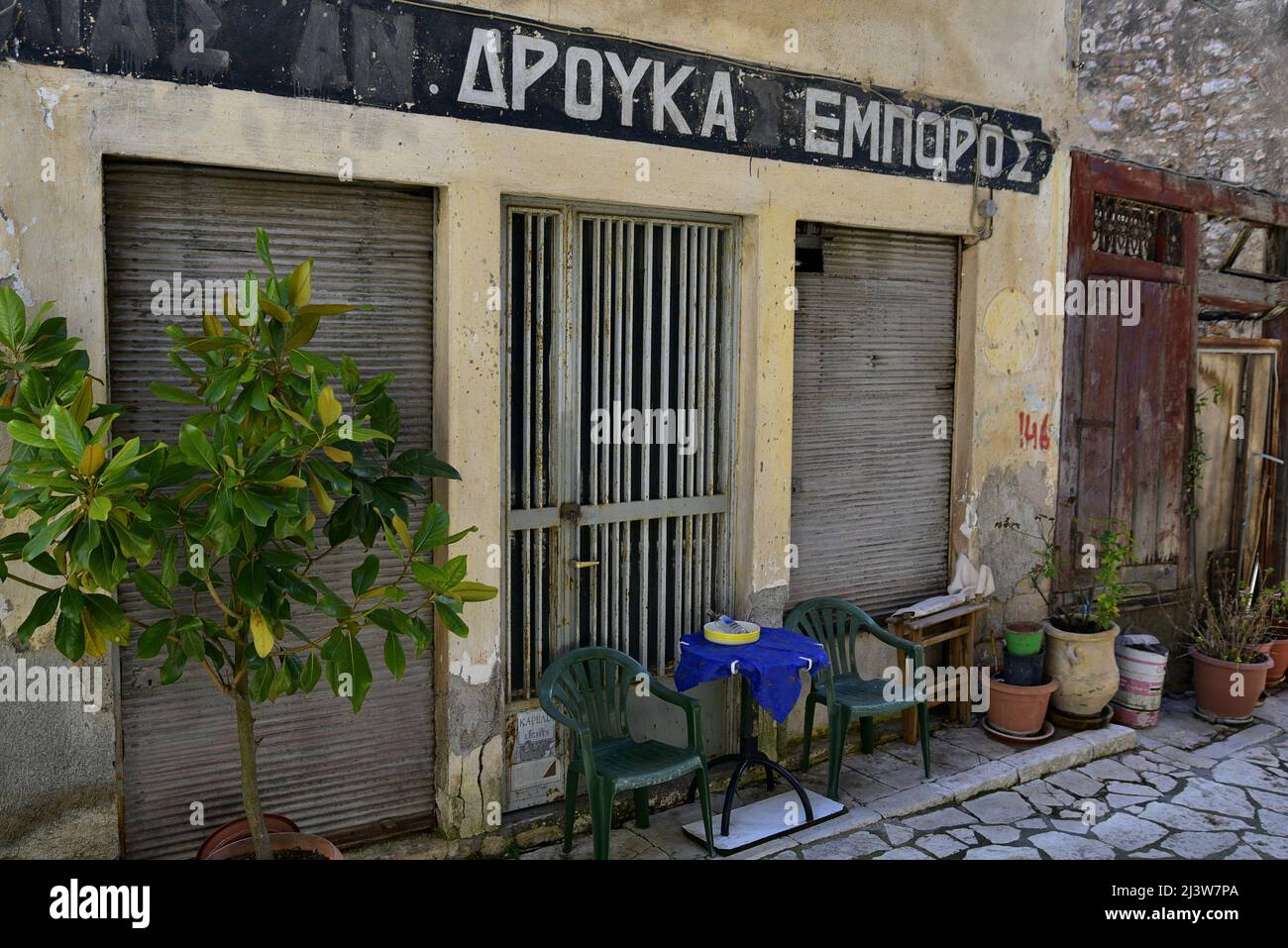Old abandoned commercial store with a store sign written in Greek on ...