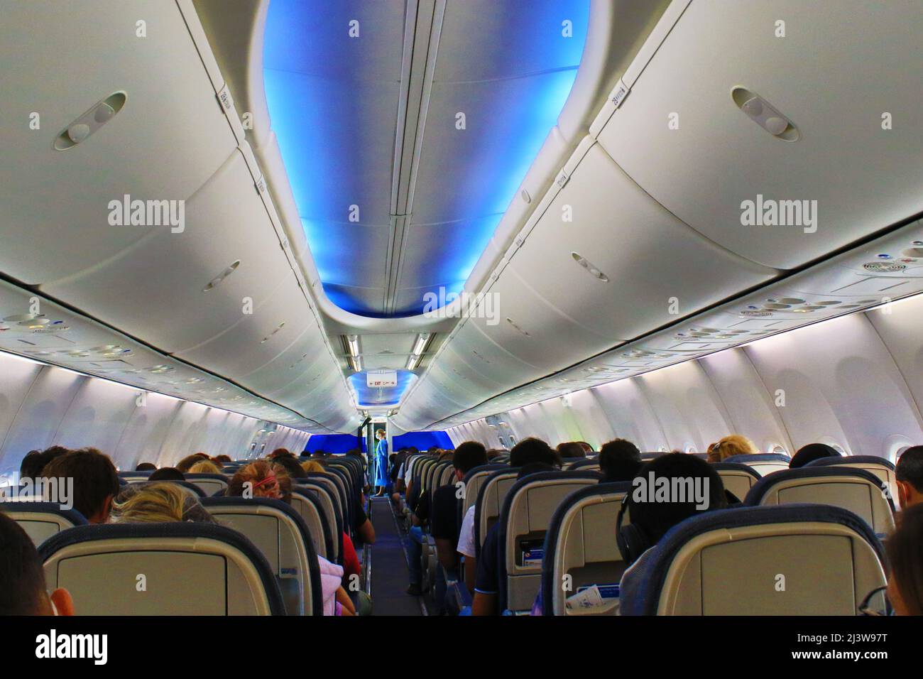 Airplane interior with rows of seated airline passengers from Dubai,UAE ...