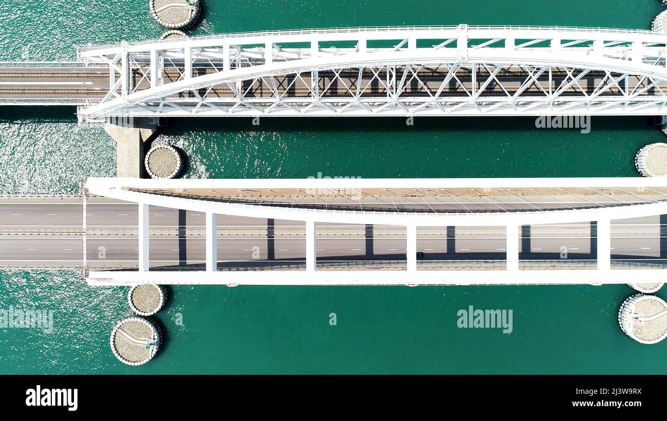 Top view of big bridge over green river. Action. Big white bridge with ...