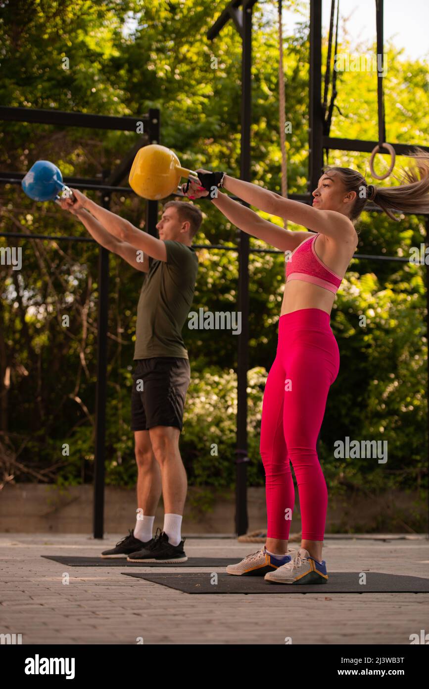 Couple is training together while doing a lifting weight exercise Stock ...