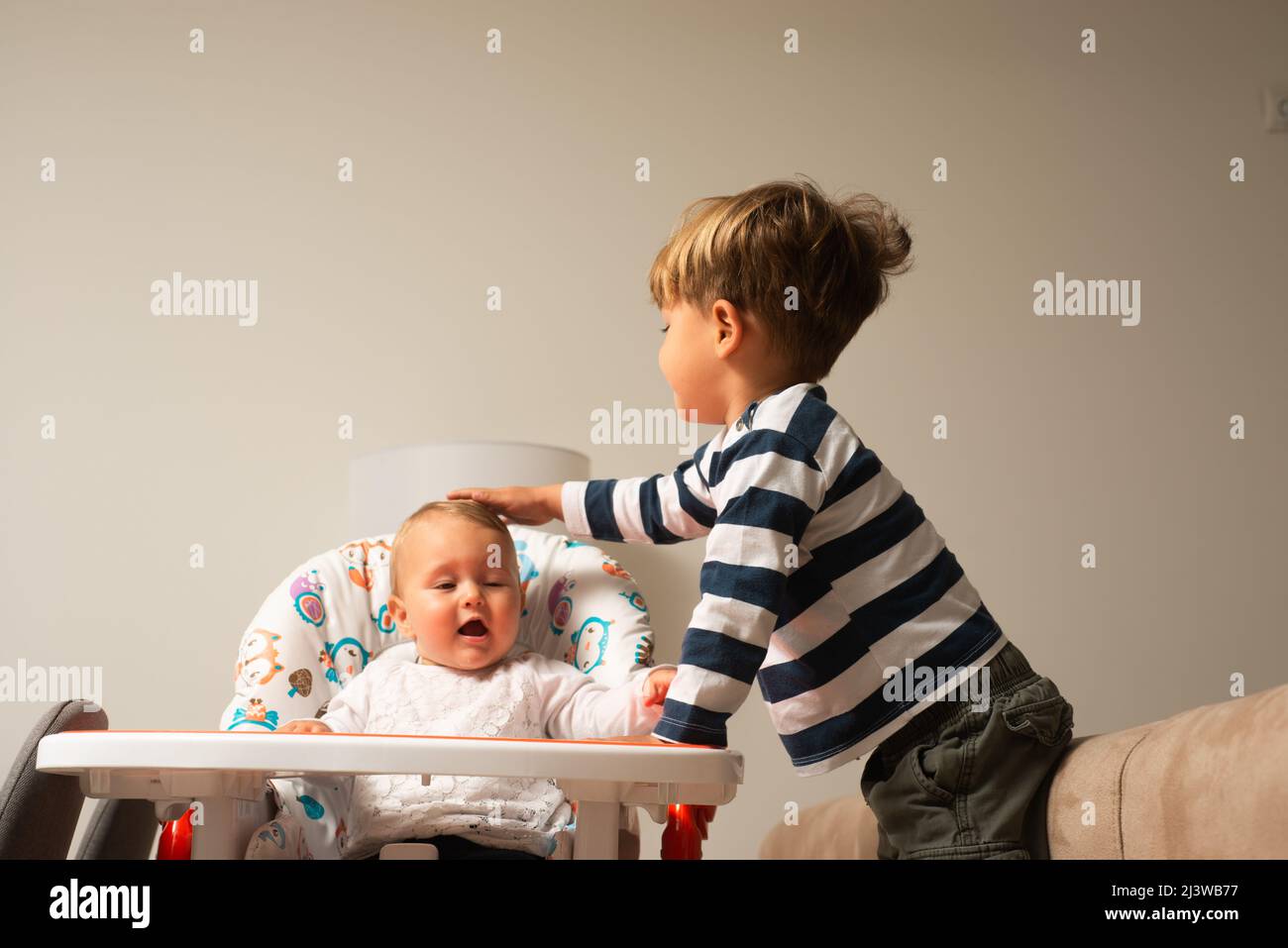 Sweet younger brother is taking care of his little baby sister Stock ...