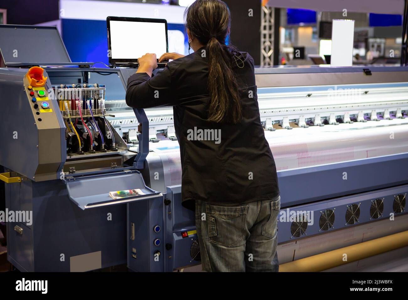 Industrial technician operating wide format digital inkjet printer ...