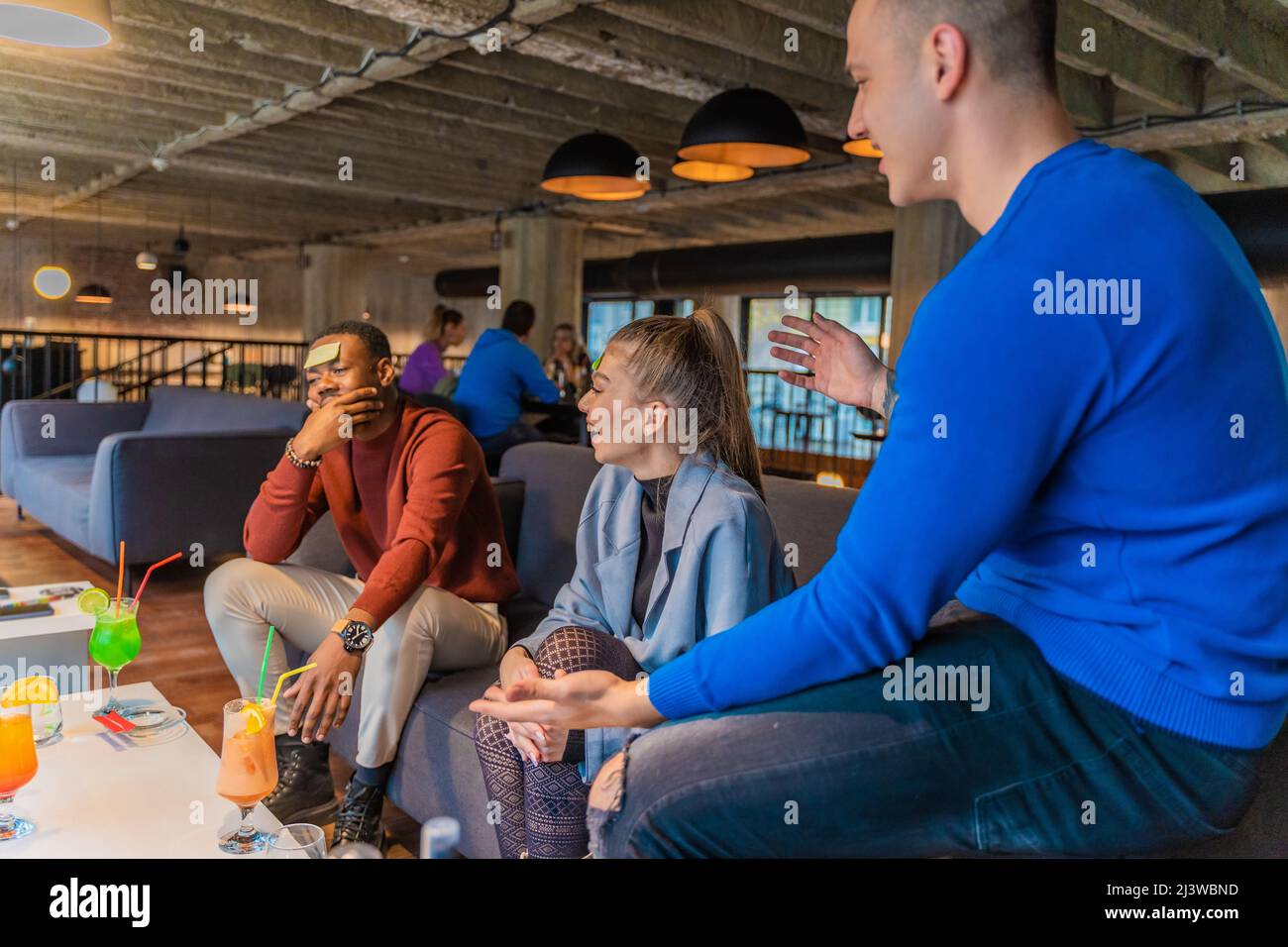 Three multiracial friends are smiling and thinking about the words ...