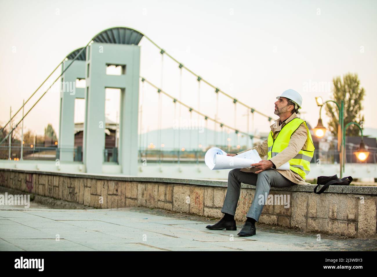 Construction manager is looking and thinking about the plans alone by ...