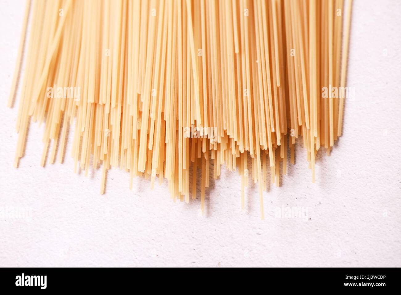 Yellow long spaghetti on white background Stock Photo - Alamy