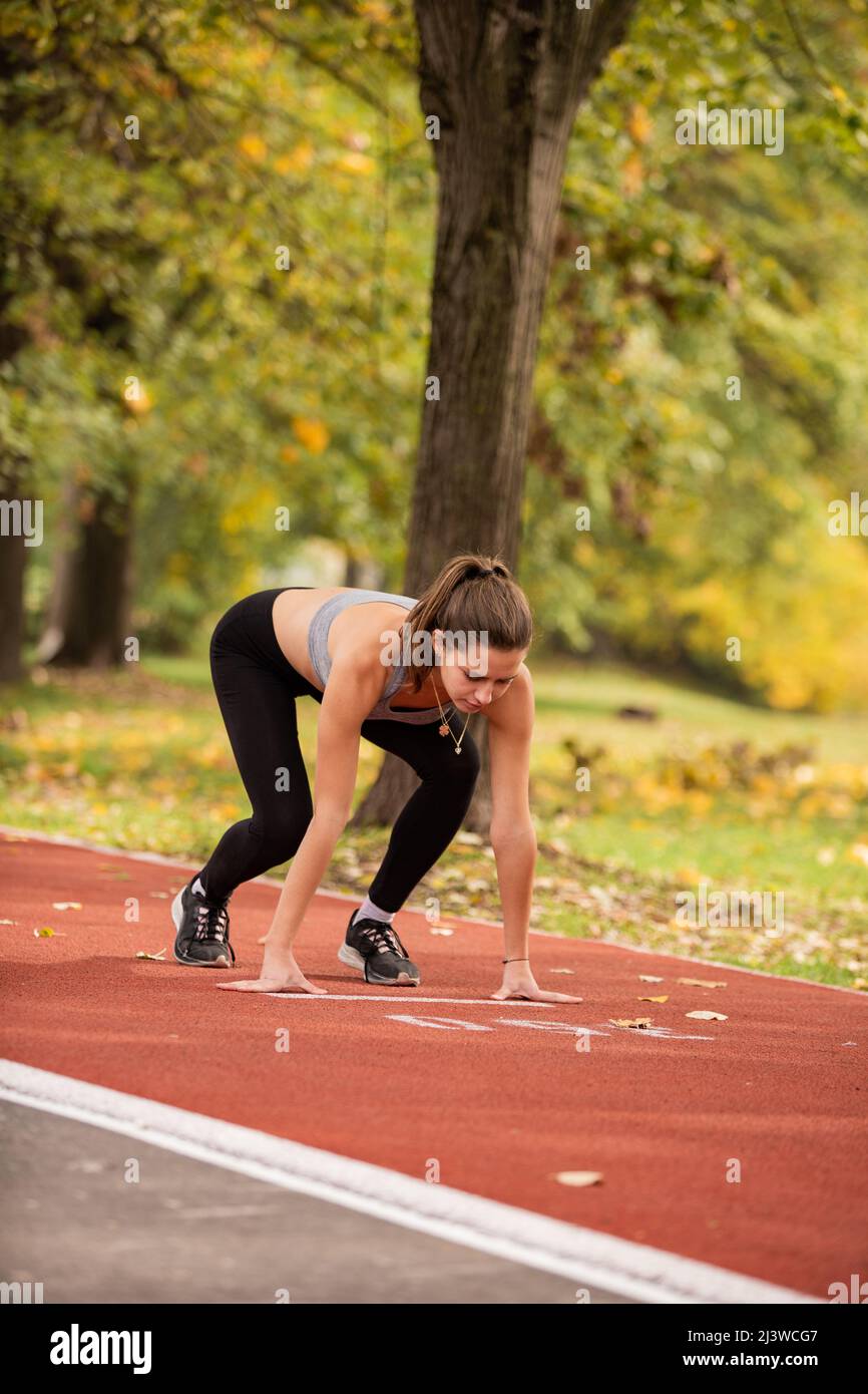 Attractive and beautiful fit girl is preparing and focusing on the run ...