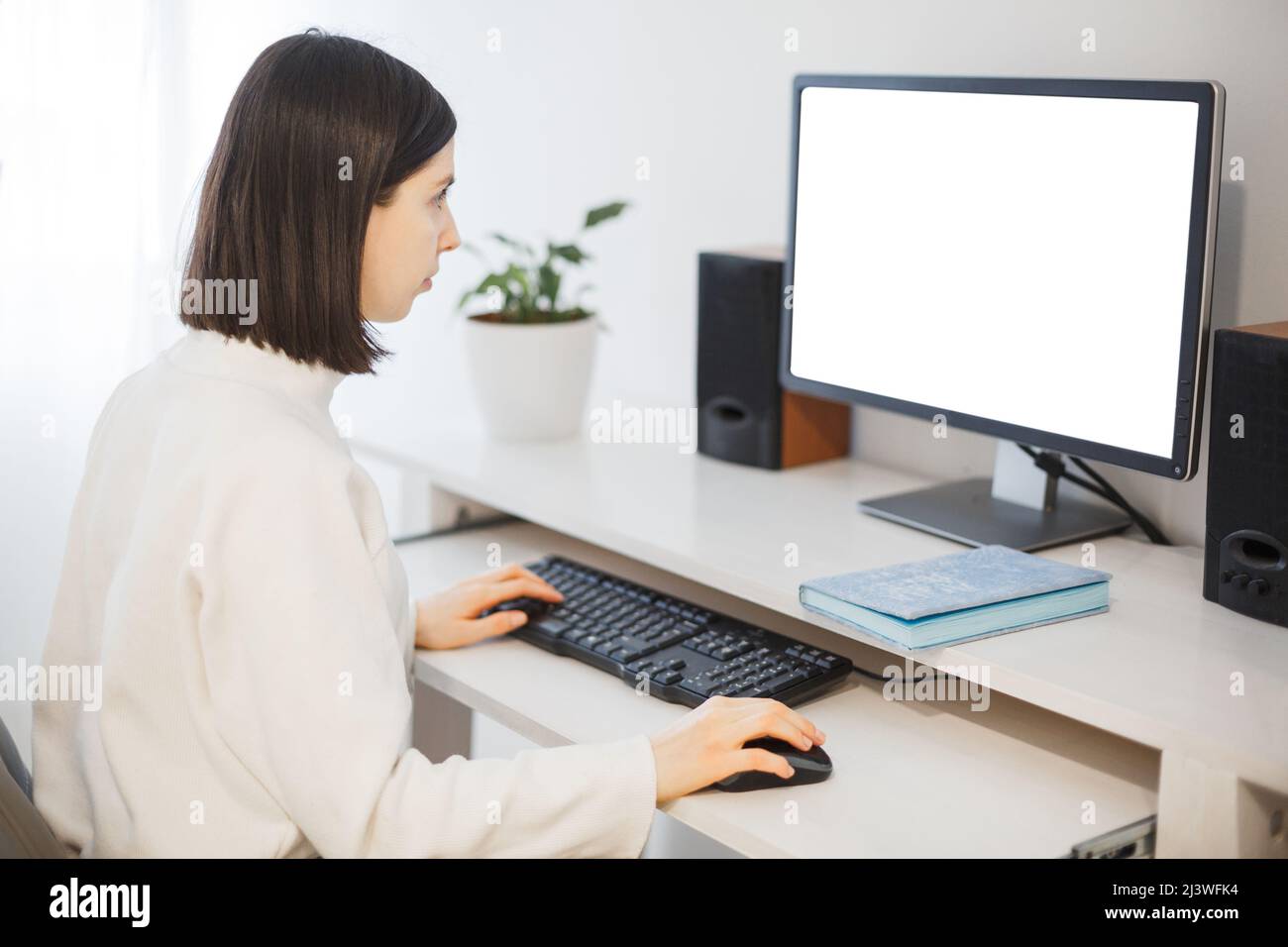 a young freelance woman is sitting at her desk and working on a ...