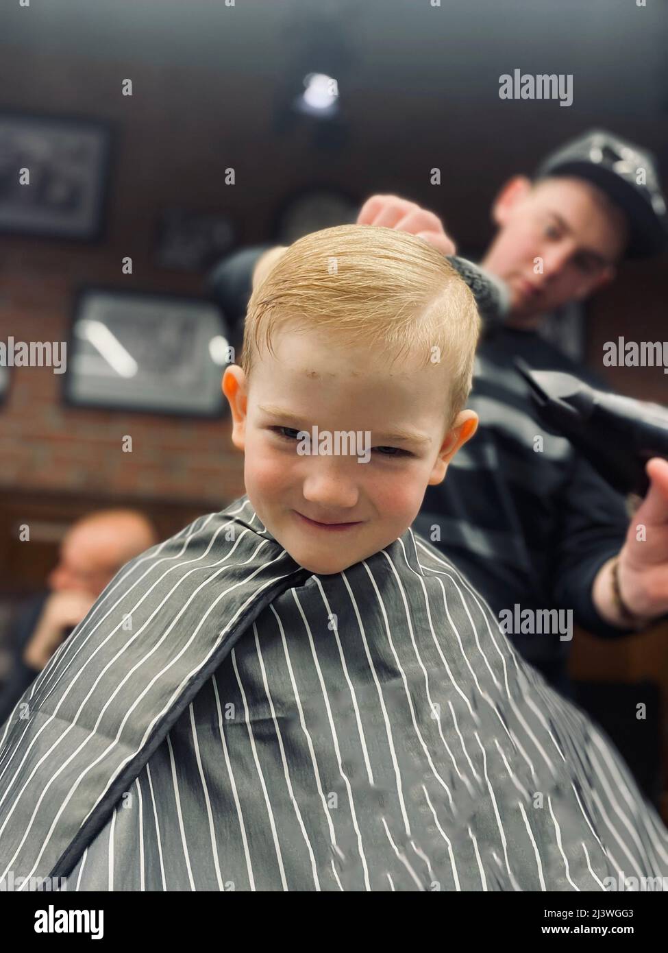 Master cuts a little boy's hair in a barbershop Stock Photo - Alamy