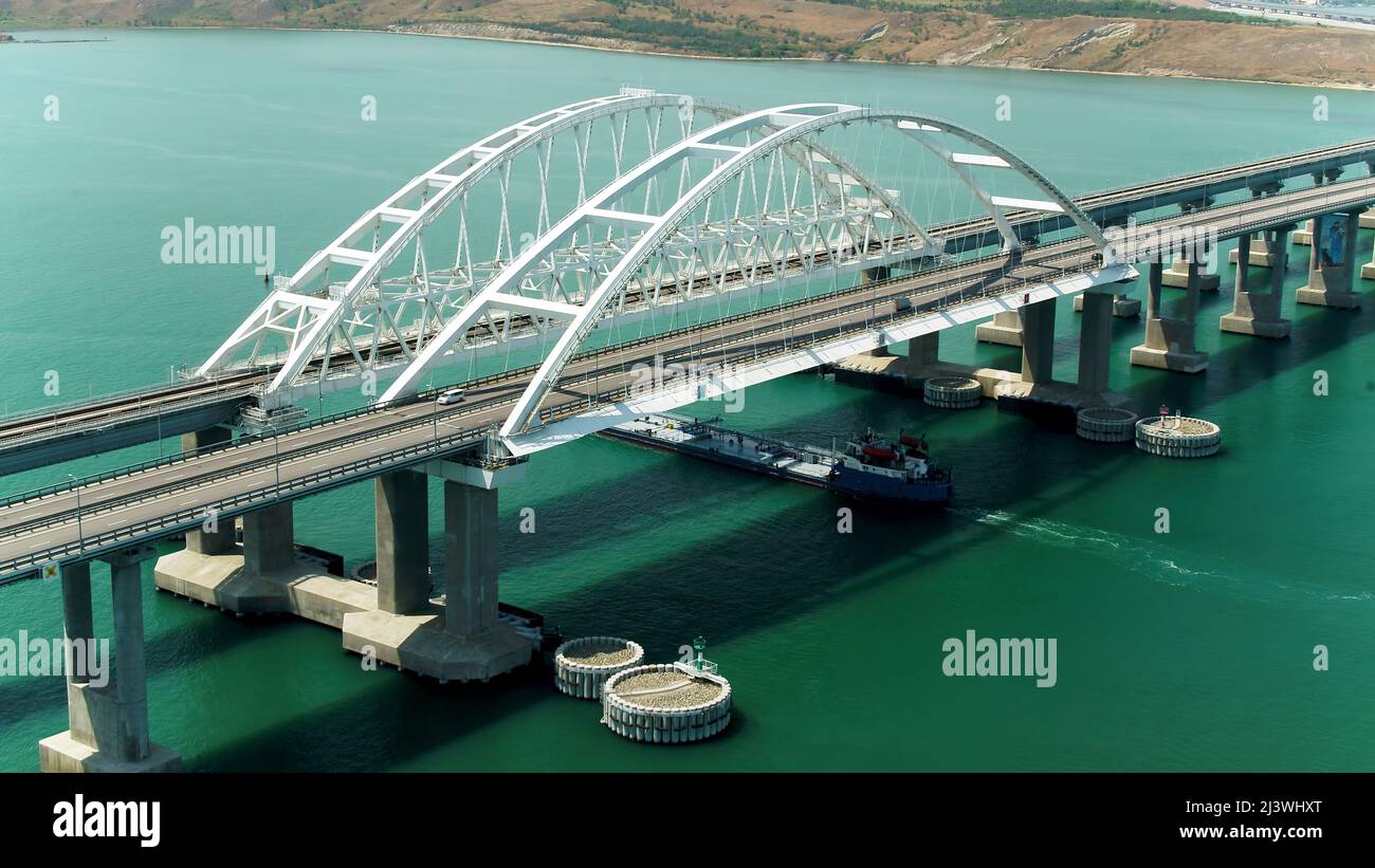 Top view of big bridge over green river. Action. Big white bridge with ...