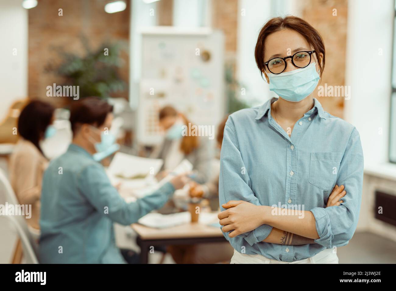Woman wearing a protective mask while working in the office Stock Photo ...