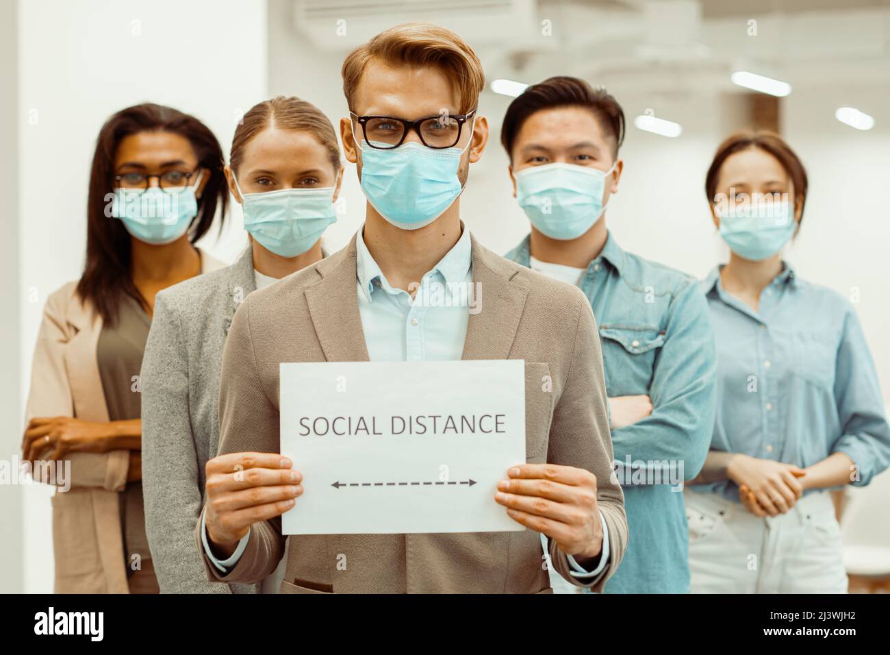 Manager with colleagues in facial covers protect from COVID-19 ...