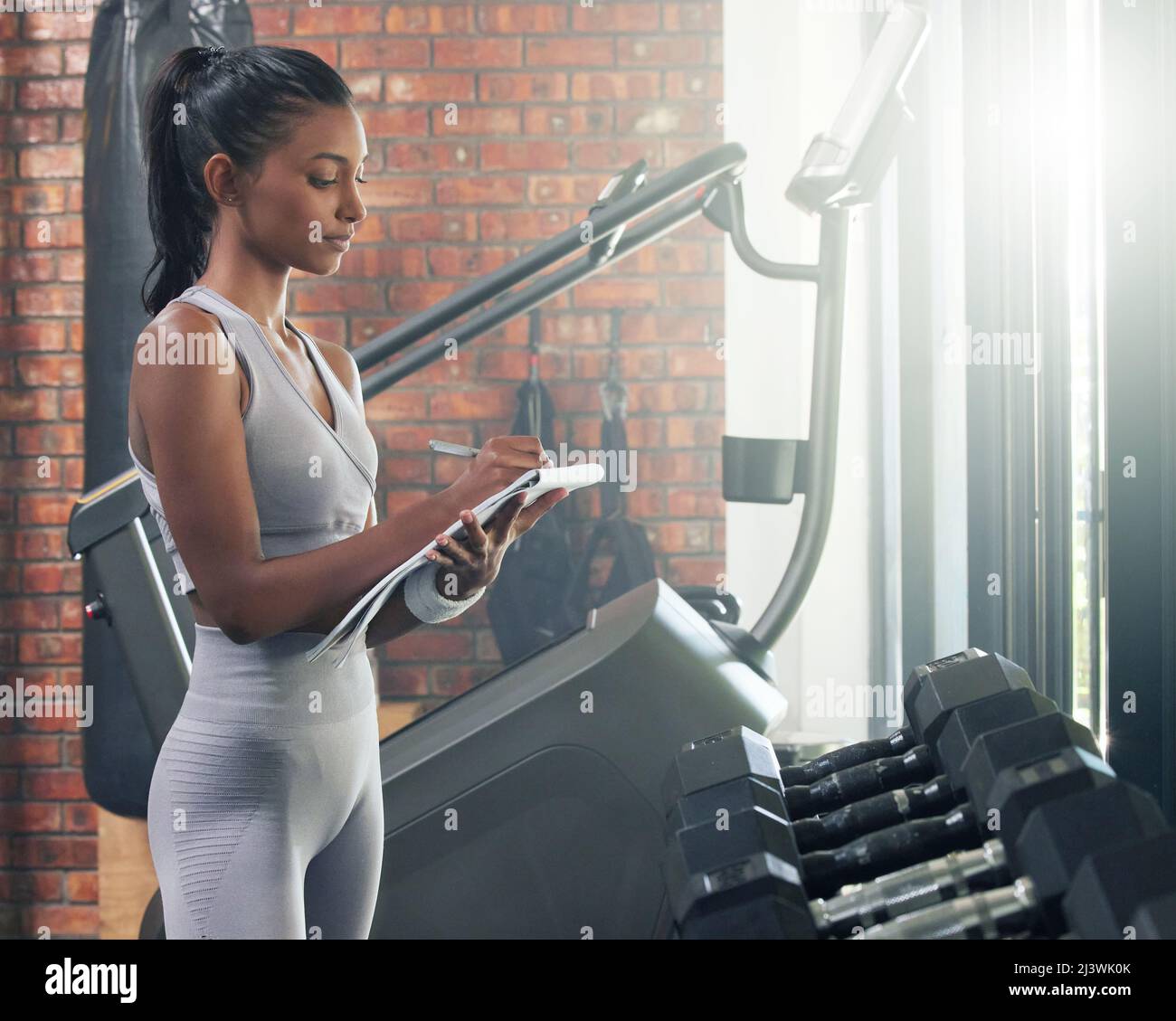 Planning a workout schedule for the week. Shot of a sporty young woman ...
