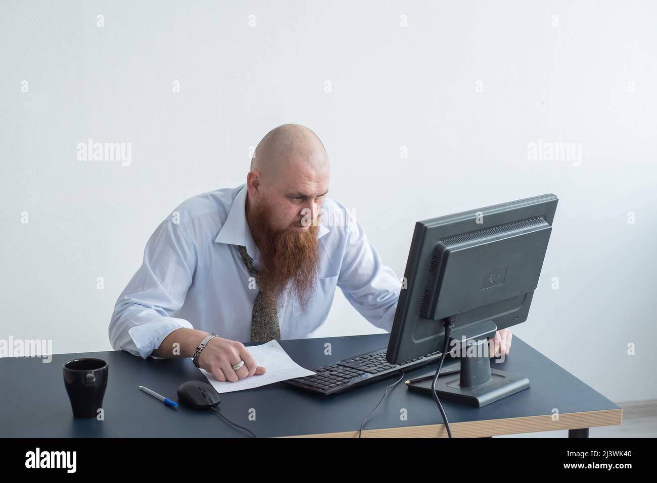 Problems for the office worker. A bald man in a white shirt sits at a ...