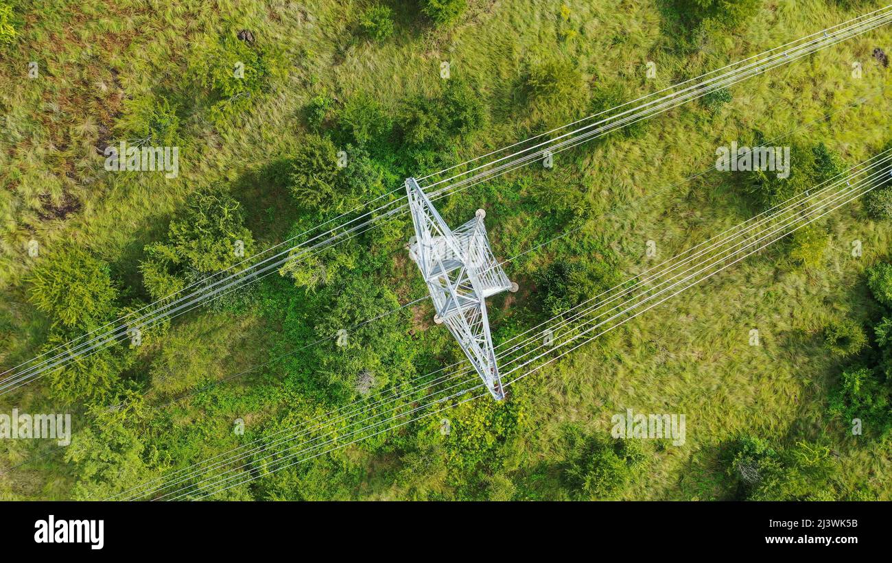 Aerial top down view high voltage steel power pylons in green field ...