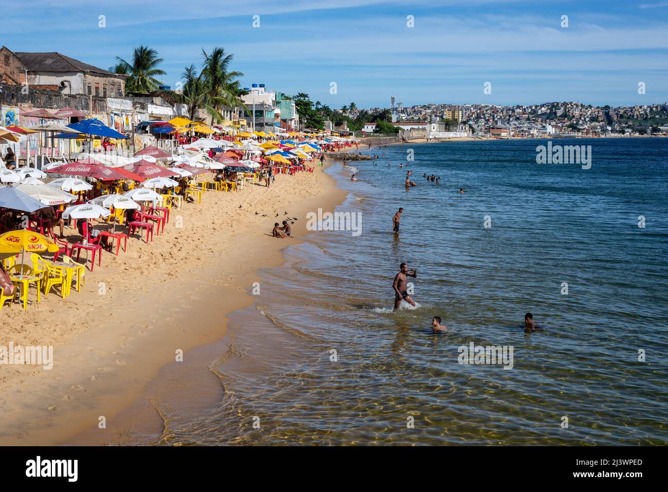 Bathers on Boa Viagem beach enjoying the strong sun in Salvador city ...