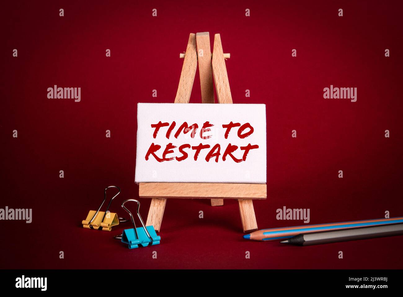 TIME TO RESTART. Miniature easel with text on a red background Stock ...