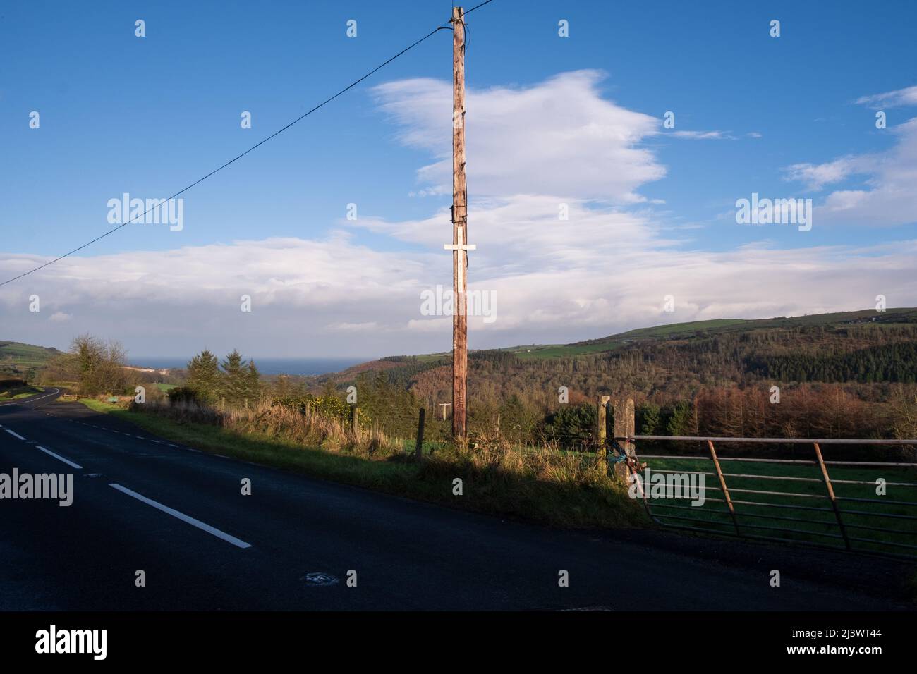 White Cross on telegraph pole with views over the forest, hills and ...