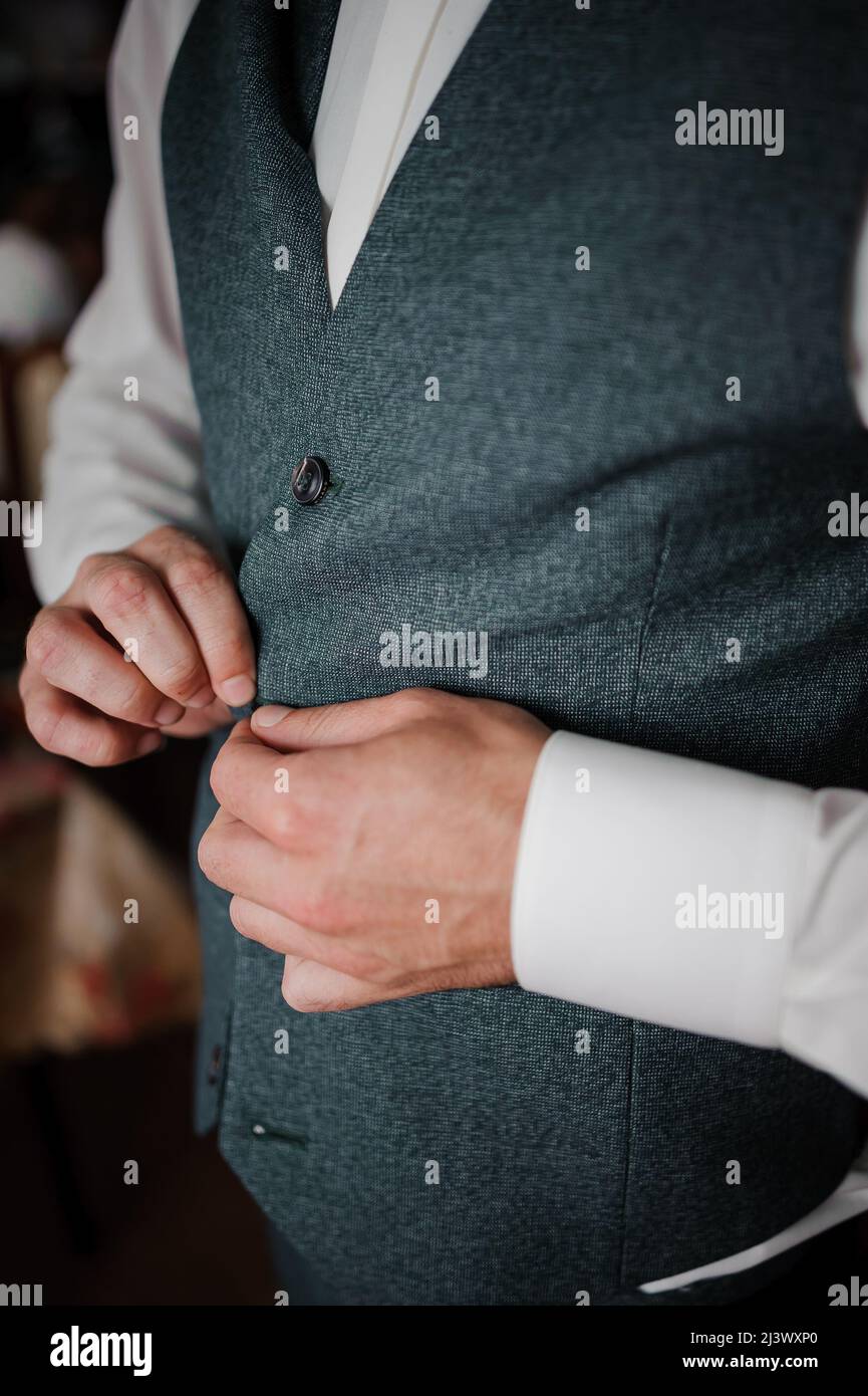 The man fasten a button on his jacket Stock Photo - Alamy