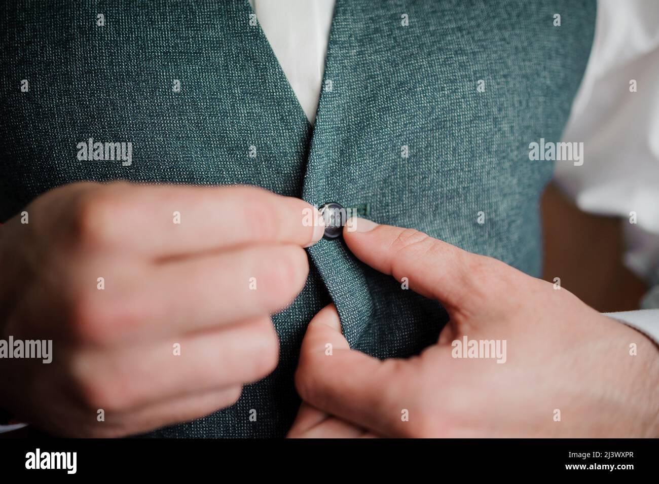 The man fasten a button on his jacket Stock Photo - Alamy
