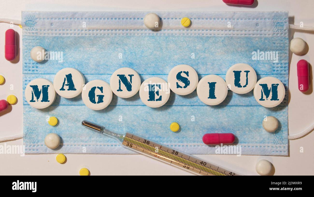 Organic pumpkin seeds with the word magnesium on small wooden dices ...