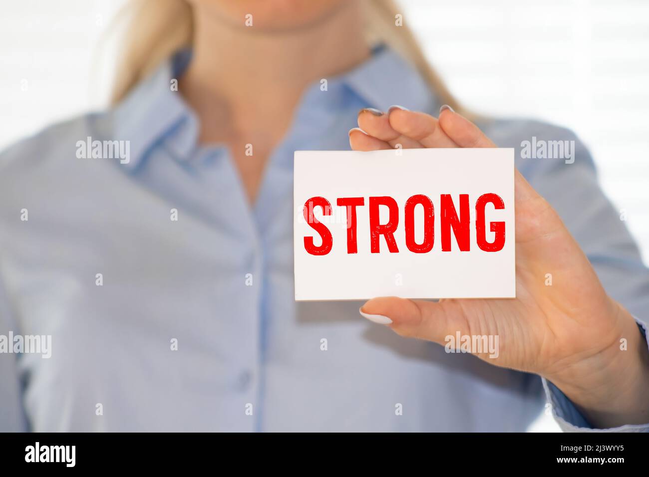Be strong symbol. Wooden clothespin with white sheet of paper. Words ...