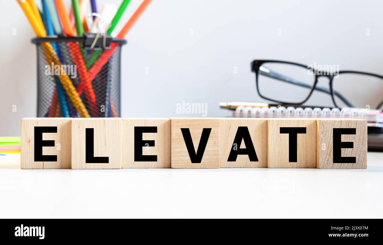 Elevate word concept, wooden block Stock Photo - Alamy