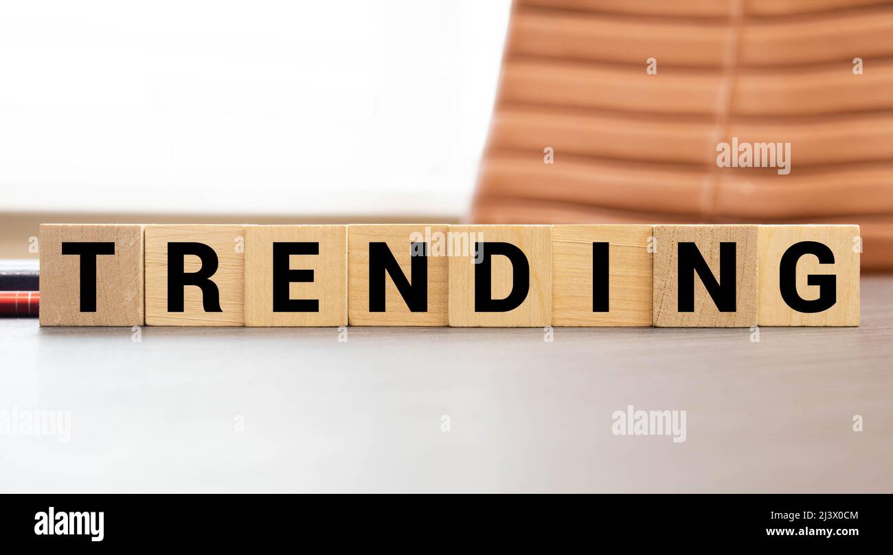 Word trending. The phrase is laid out in wooden letters. Top view. Blue ...